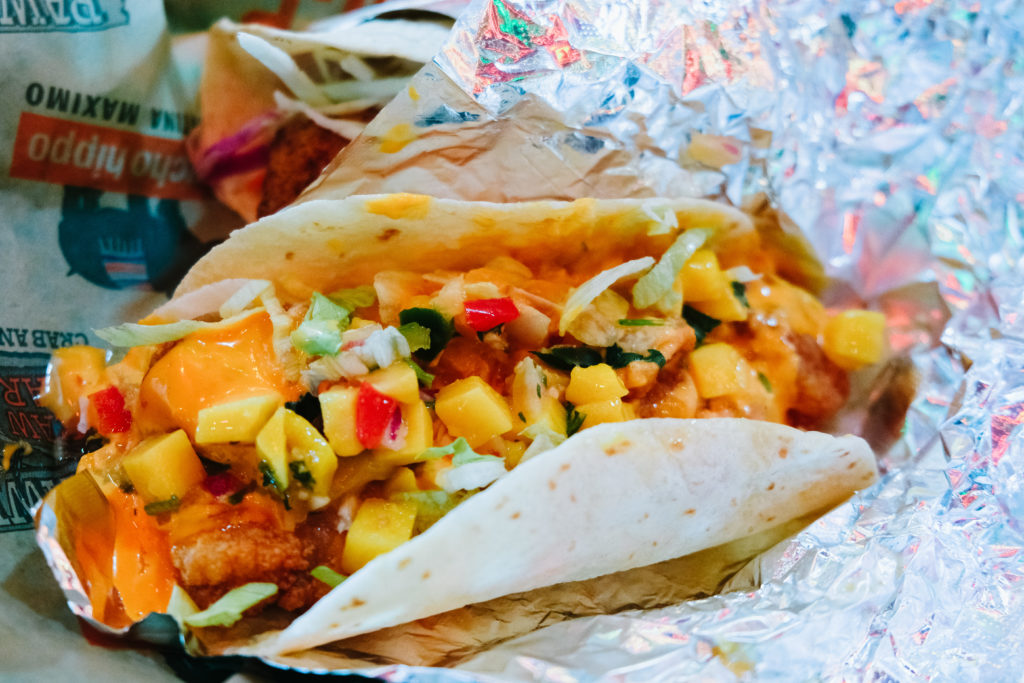 Try the best street tacos + mile-high nachos at Nacho Hippo